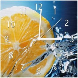 Wallario Wanduhr Orange in spritzigem Wasser vor blauem Hintergrund (Aluverbunduhr), gelb, mit weißen Zeigern