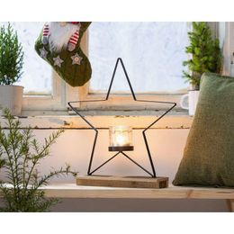 Windlicht Stern aus Metall, schwarz, 39 cm hoch, Sockel aus recyceltem Holz, Teelichthalter, Sternendeko mit Glaswindlicht