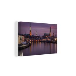 OneMillionCanvasses® OneMillionCanvasses® Leinwandbild Lübeck am Abend mit Spiegelung auf dem Wasser