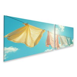 islandburner Leinwandbild Leuchtende Pastelltücher trocknen an einer Leine vor blauem, sonnigen
