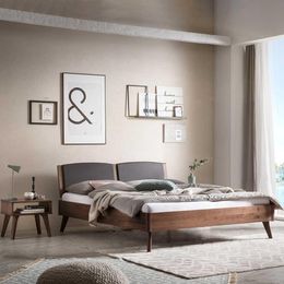 Pharao24.de Massivholz Bettgestell Nussbaum in modernem Design mit Polsterkopfteil Dunkelgrau
