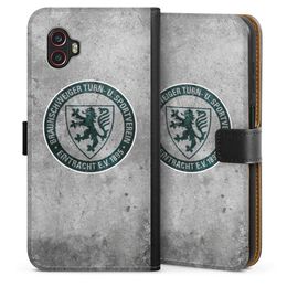 DeinDesign Galaxy XCover 6 Pro Handy Klapph&uuml;lle Handyh&uuml;lle aus Kunst Leder schwarz Flip Case Logo Eintracht Braunschweig Concrete Sideflip mit langer Lasche